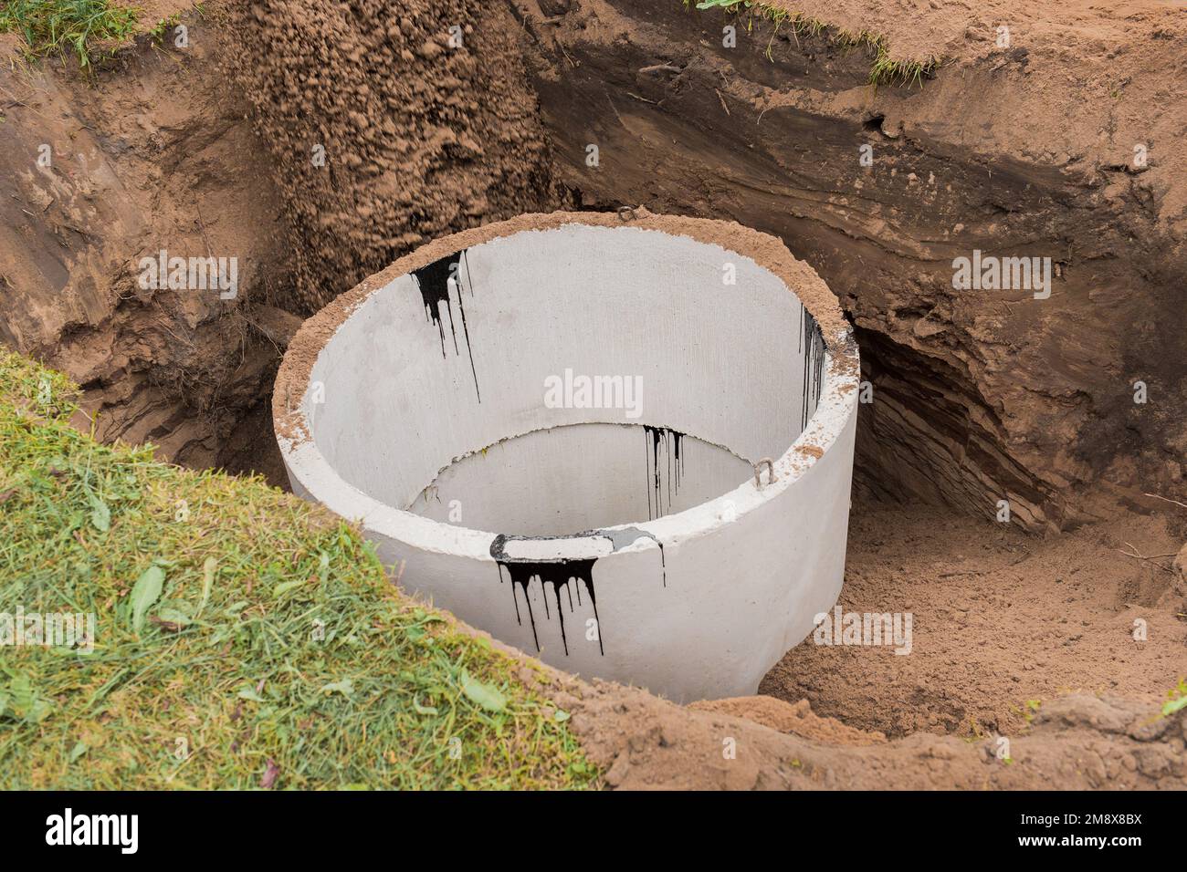Concrete sewer rings in the ground. Construction or repair of sewerage ...