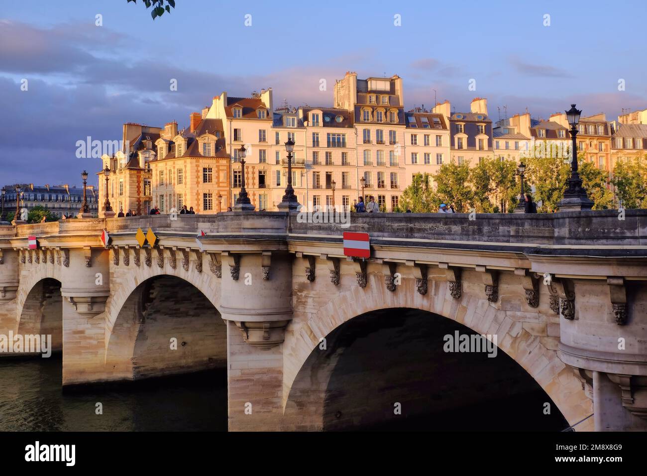 Paris: Pont Neuf bridge over the Seine with buildings of Ile de la Cite glowing gold soon before ...