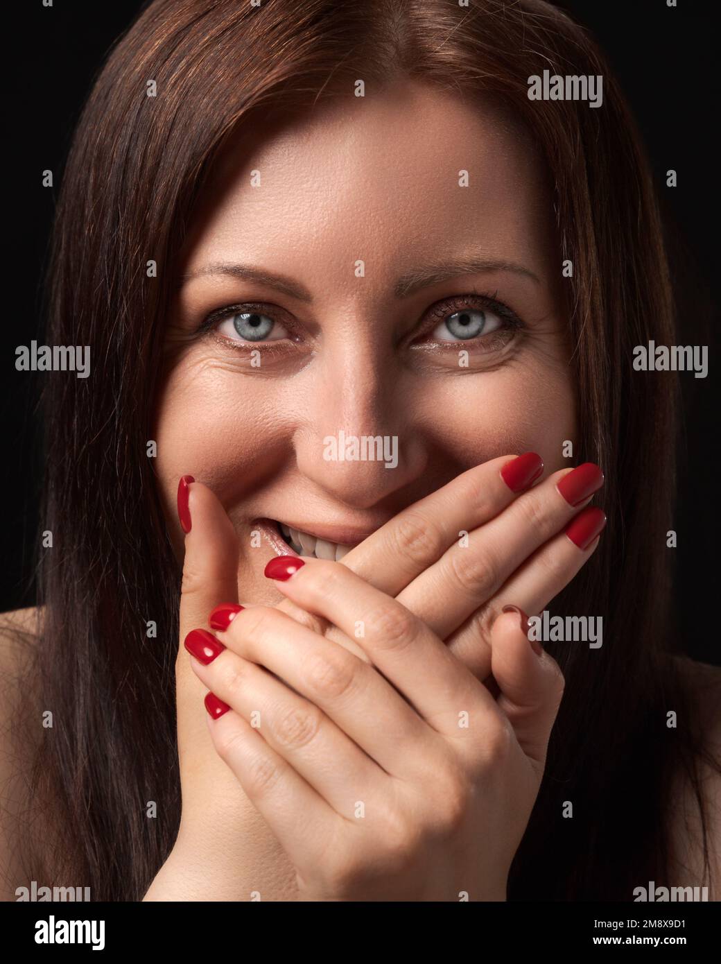 Cheerful charming woman laughing while covering mouth with her hands ...