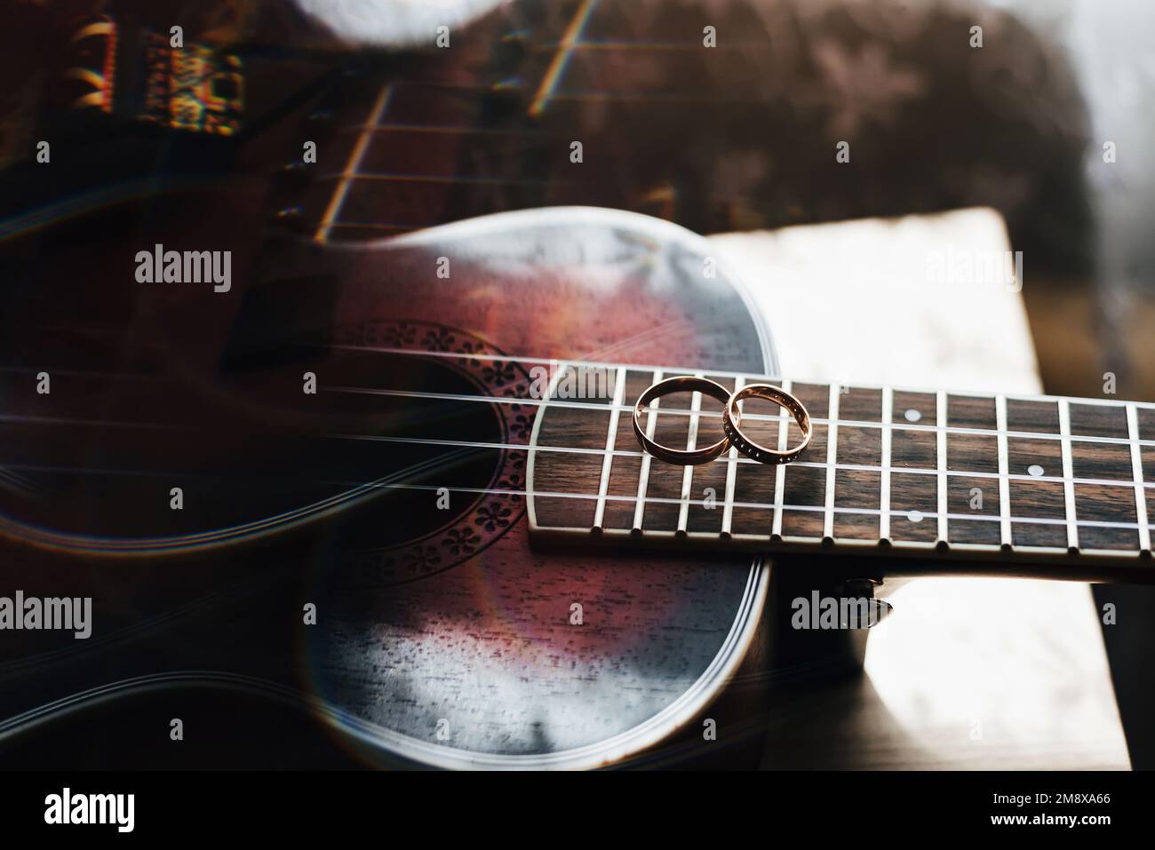 two gold wedding rings lie on guitar strings close-up Stock Photo - Alamy