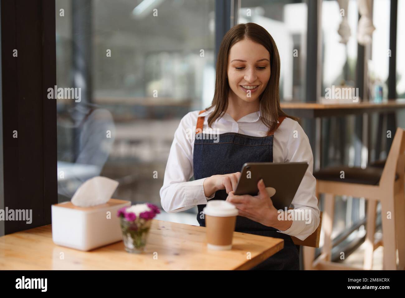 Young Female manager in restaurant with tablet. Woman coffee shop owner ...