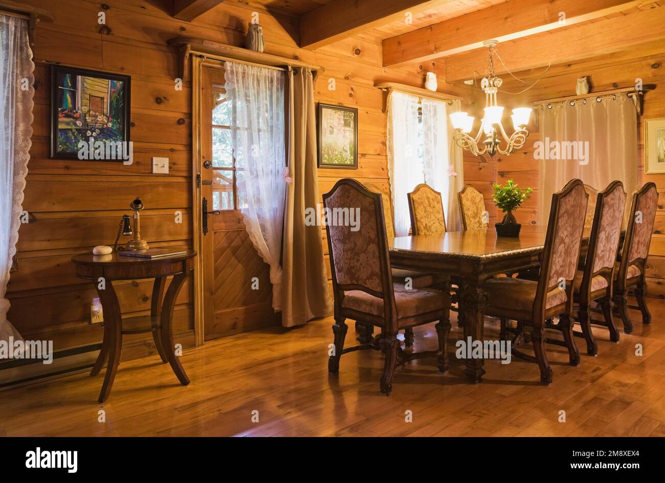 Wooden side table next to entrance door and dining table with ...