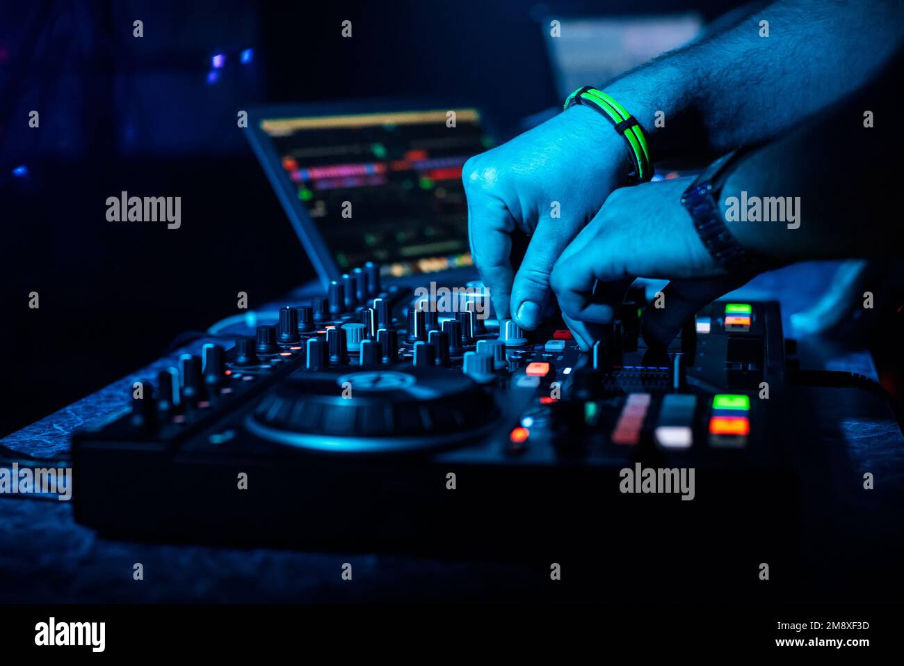 hand DJ mixing electronic music on a professional controller Board at a ...