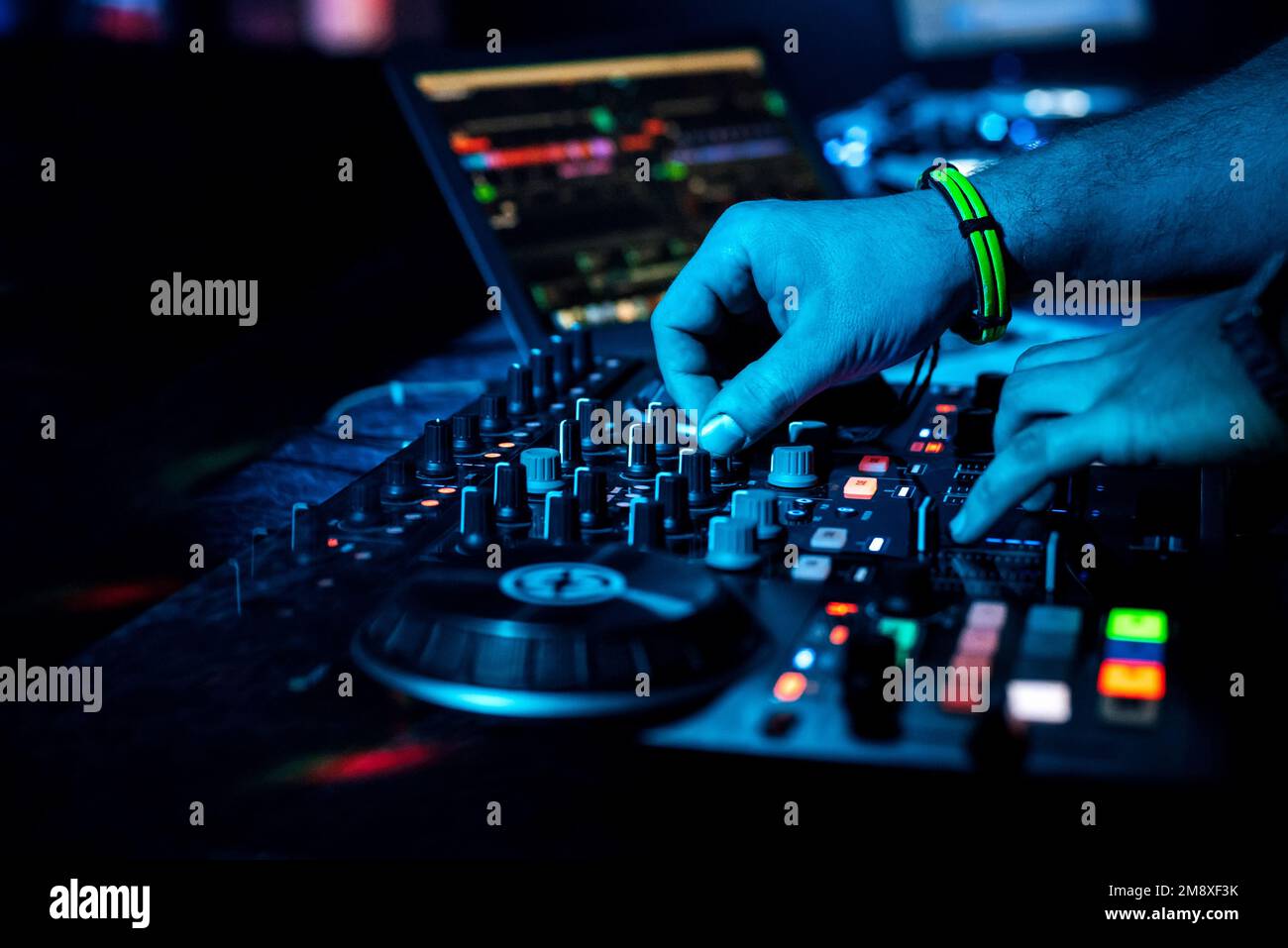 DJ hand mixes electronic music on a professional mixer in a nightclub ...