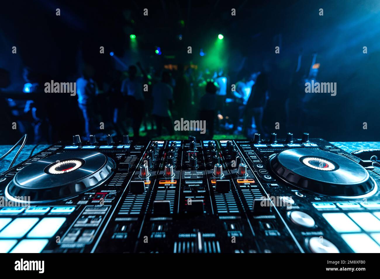 DJ music mixer in a booth in a nightclub on a blurred background of ...