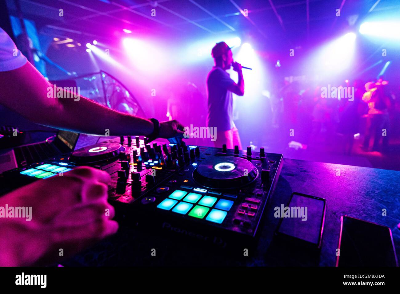artist with a microphone performs on the stage of a nightclub at a ...