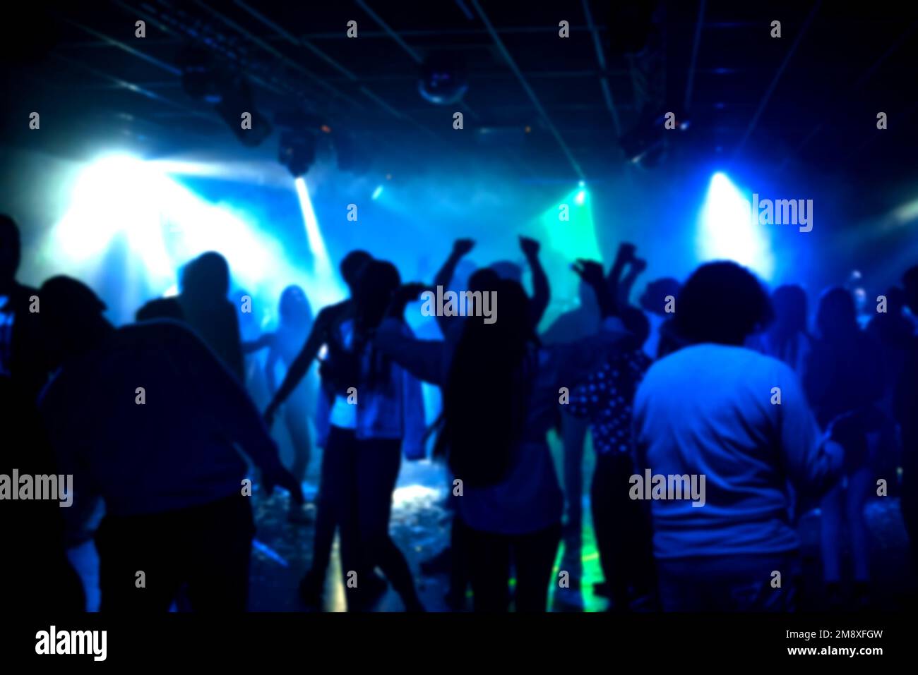 blurred silhouettes of a group of people dancing in a nightclub on the ...