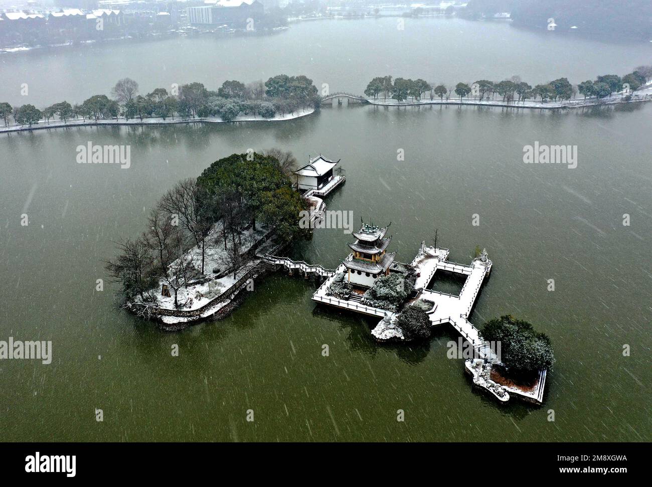 Aerial photo shows snow falling on Tianjing Lake and surrounding urban ...