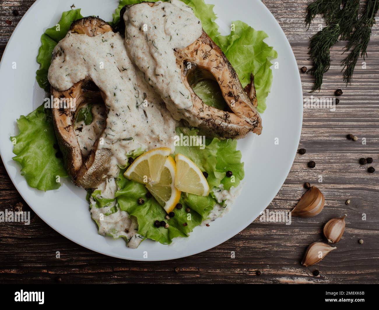 pieces of fried red fish with cream sauce on a white plate. Trout in ...