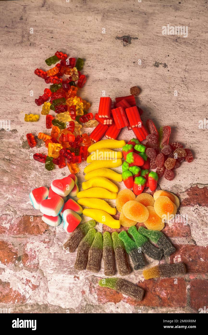 Several types of assorted jelly candies on a brick background Stock ...