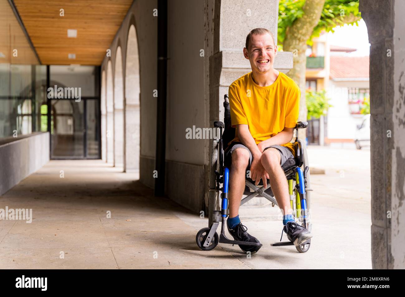 Portrait of a disabled person in a wheelchair smiling next to some ...