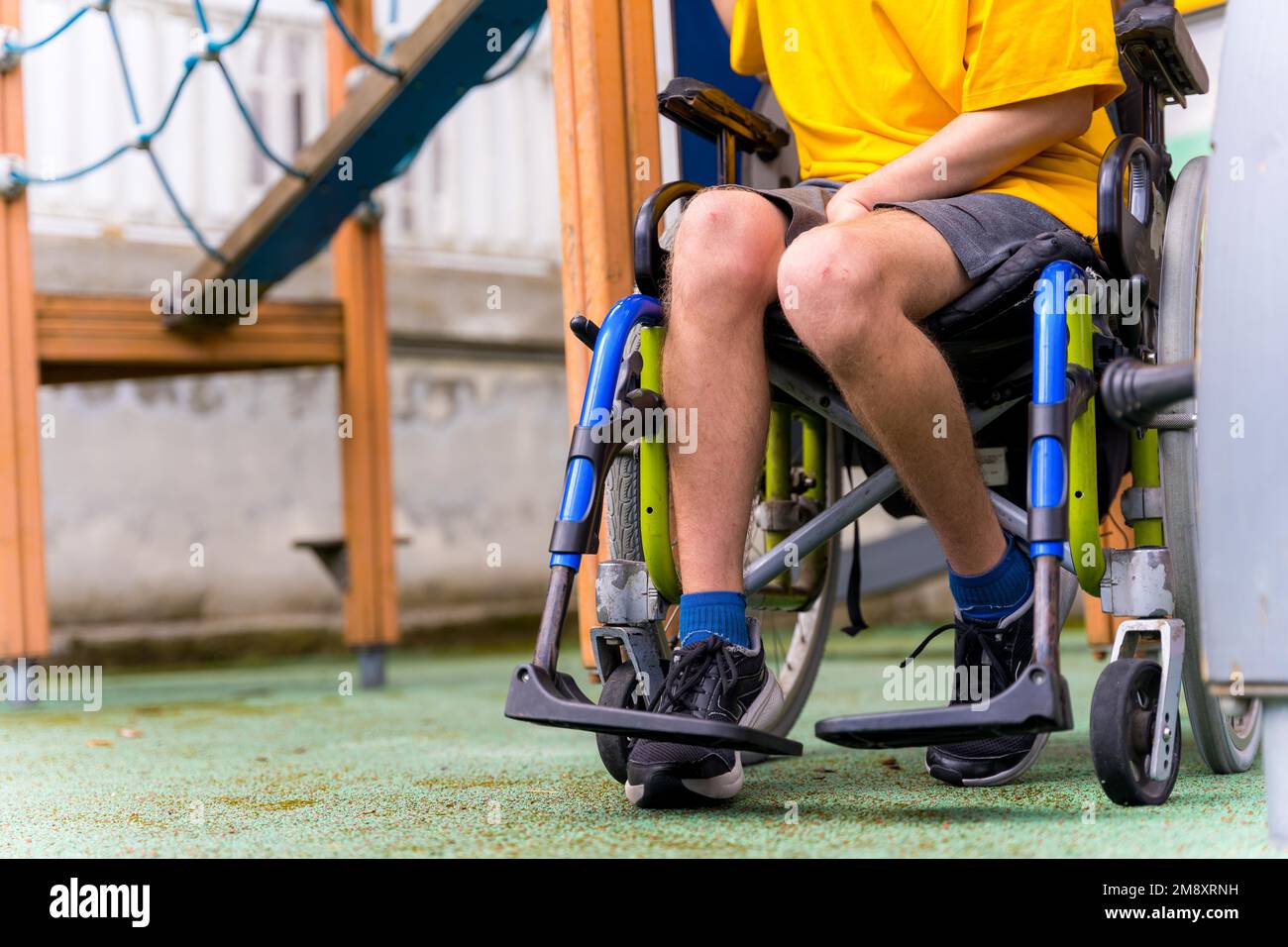 Detail of a disabled person in a wheelchair on the swings of a ...
