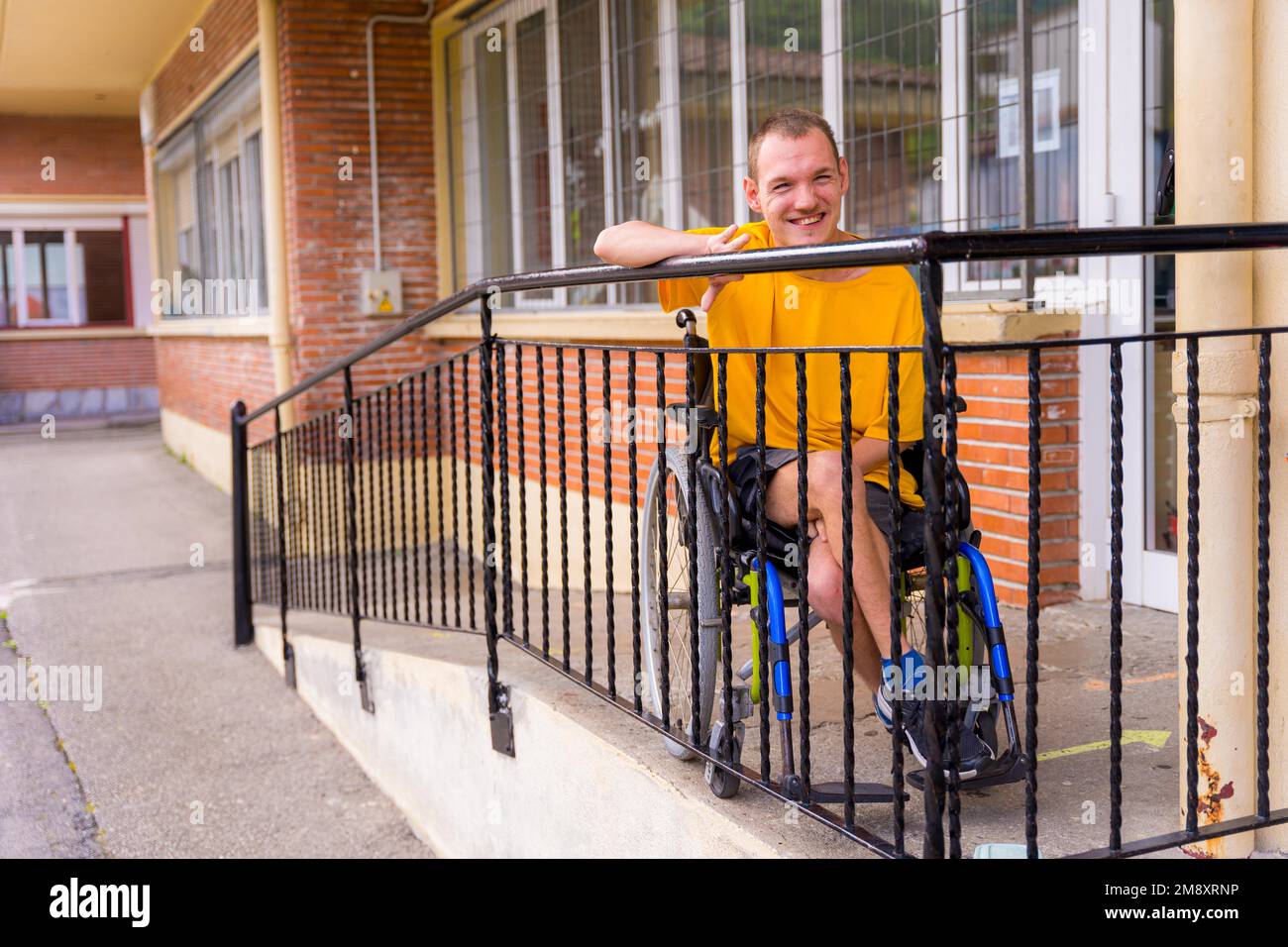 Portrait of a disabled person dressed in yellow in a wheelchair at ...