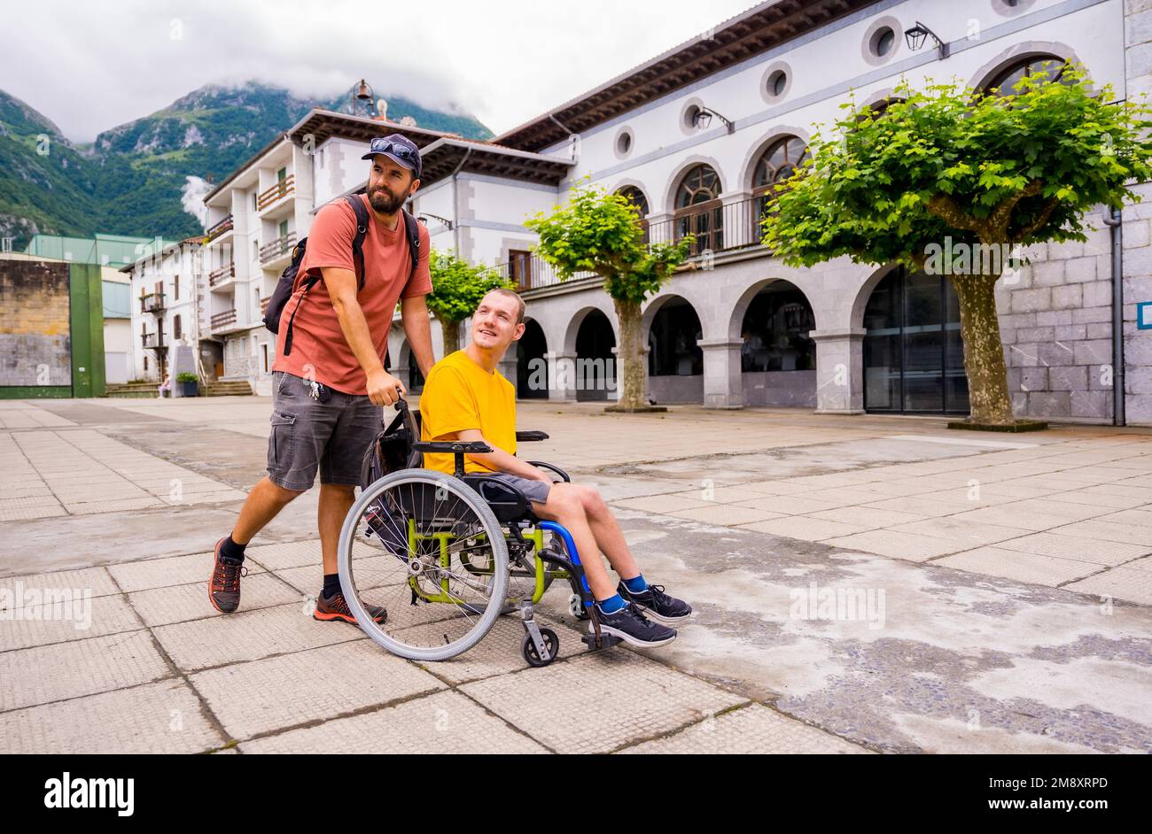 A disabled person in a wheelchair walking through the town square with ...