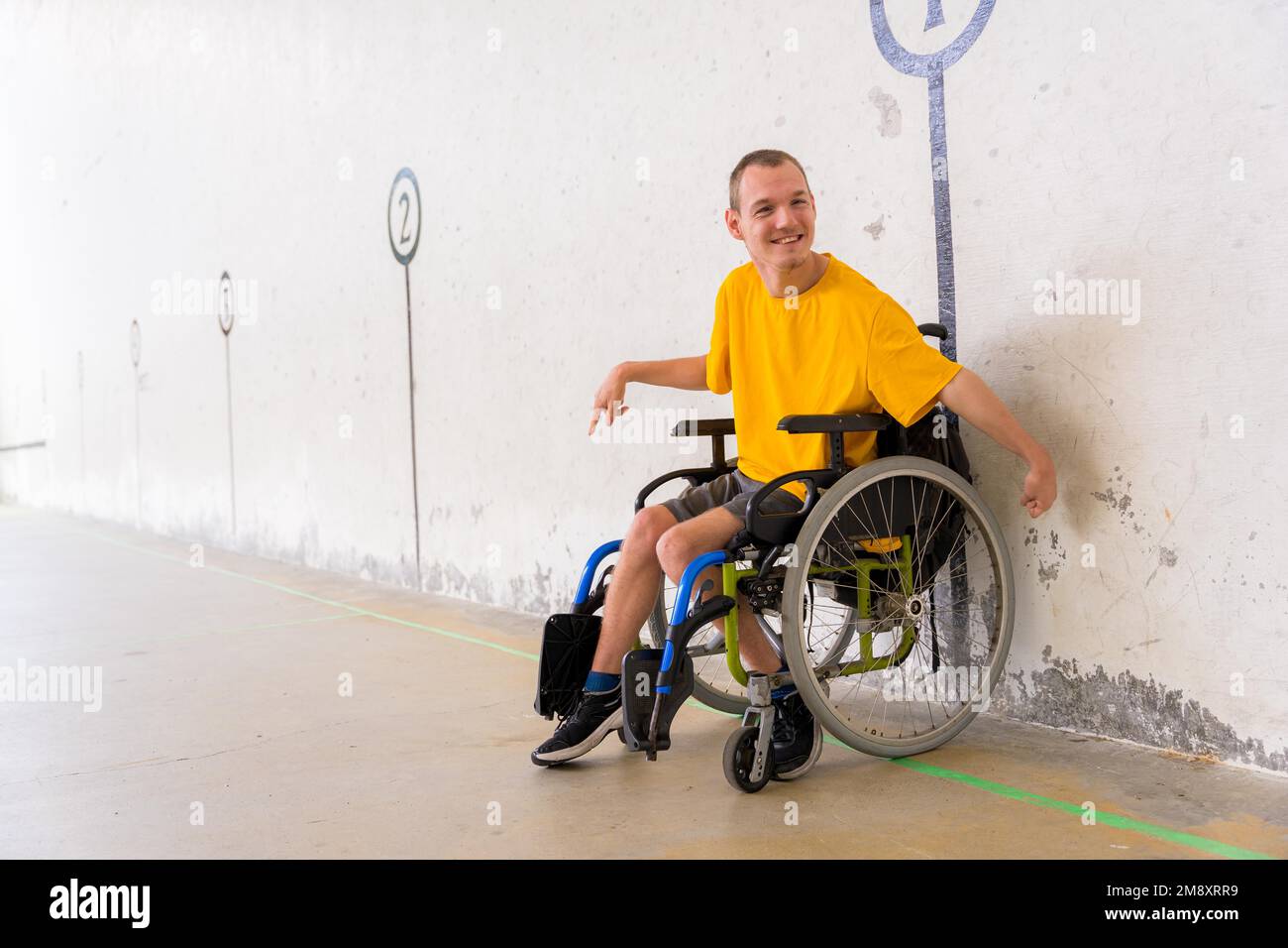 A disabled person in a wheelchair at a Basque pelota game fronton having fun Stock Photo - Alamy
