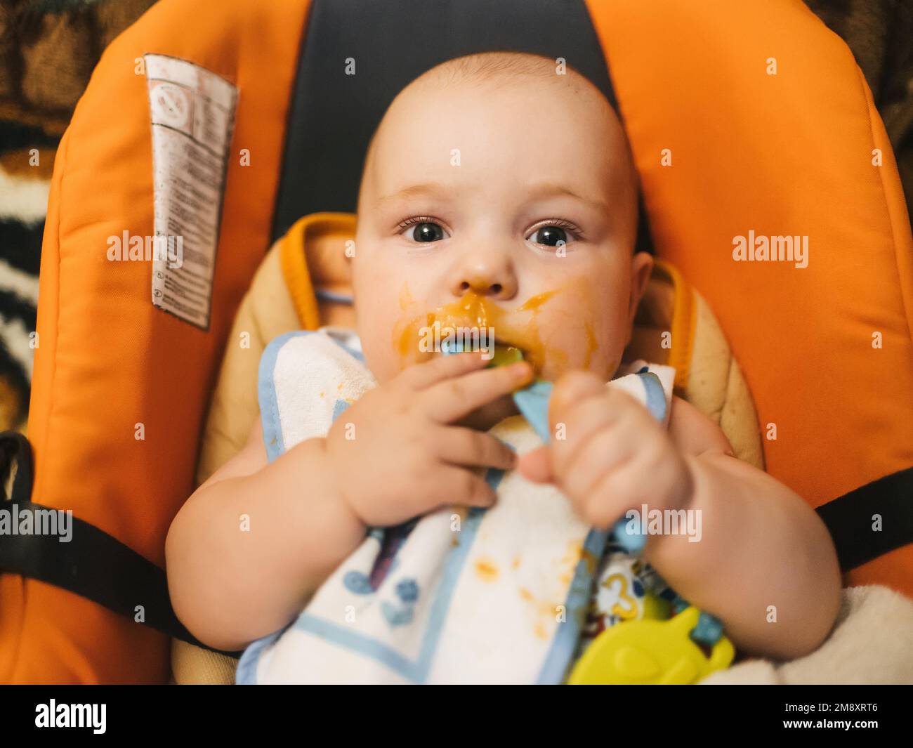 portrait of a little boy eating a baby with a spoon and a grimy face ...