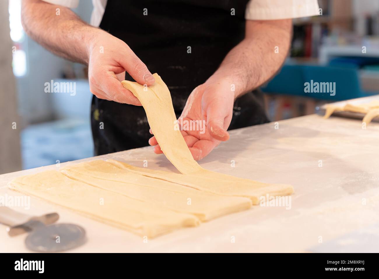 Detail of the hands of a man baking croissants collecting the ...