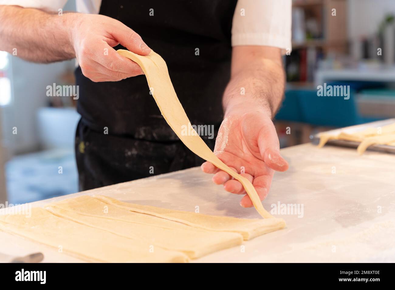 Detail of the hands of a man baking croissants collecting the ...