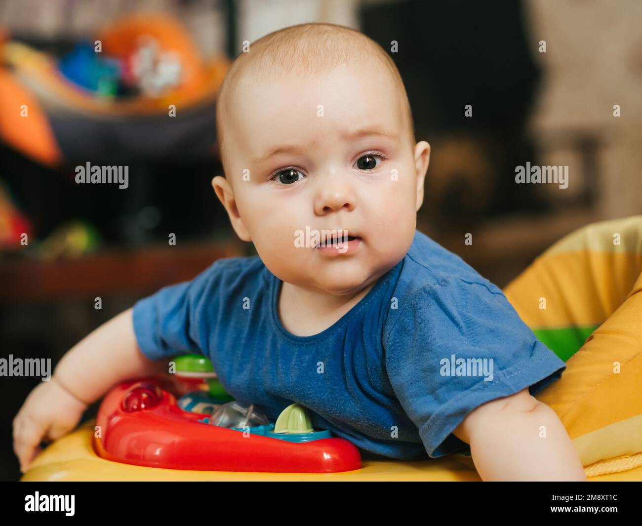 portrait of a cute little Caucasian baby boy playing in a Walker Stock ...