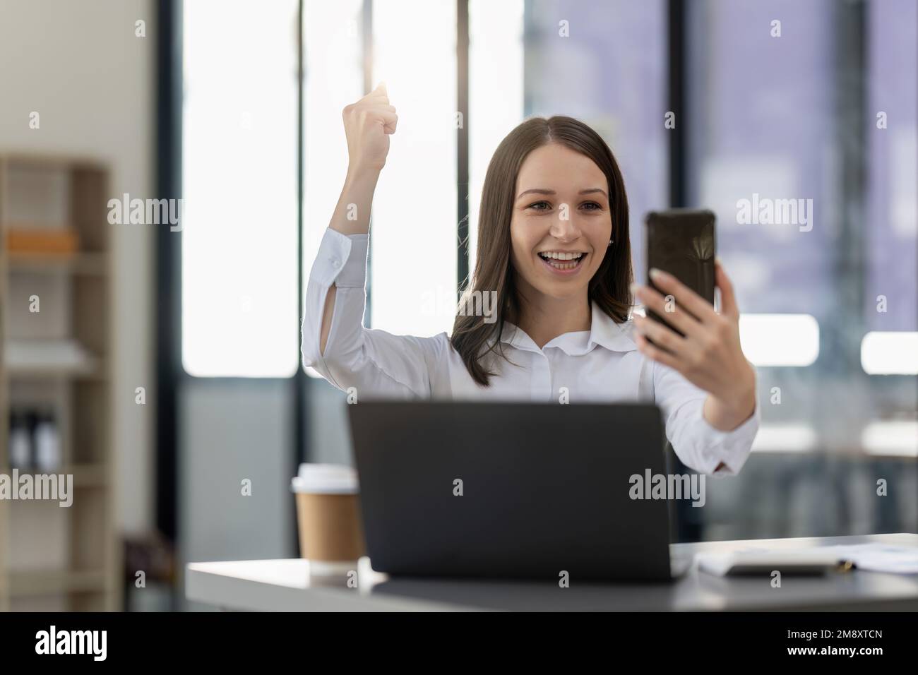 Happy emotional business woman celebrates victory. watching her mobile ...