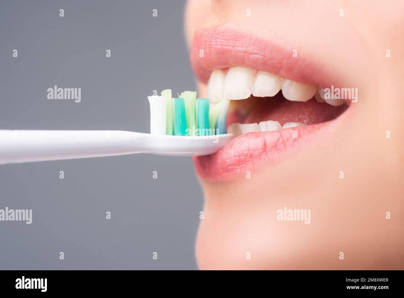 Close-up mouth with teeth-brush. Closeup on happy young woman brushing ...