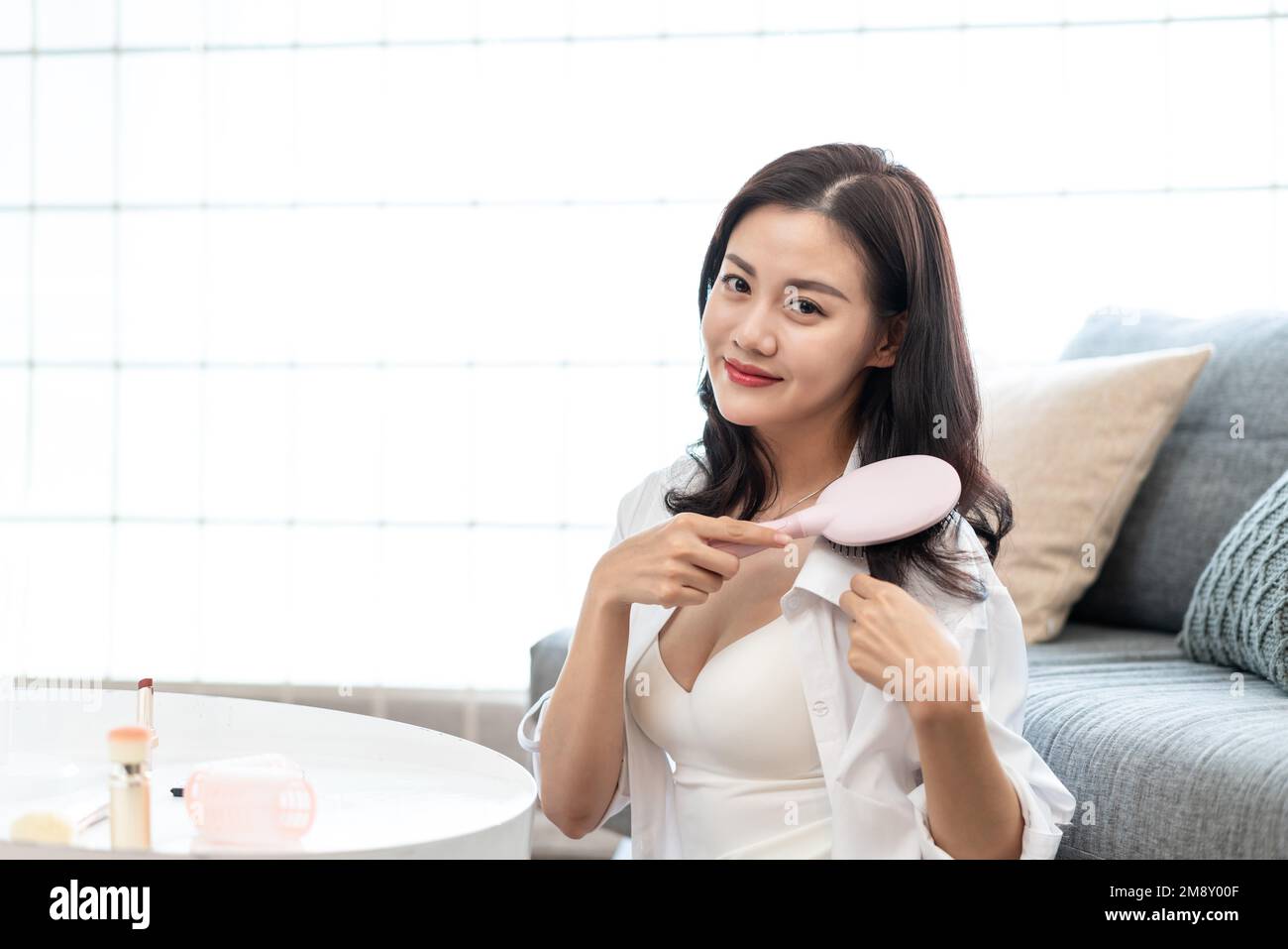 A young woman in comb my hair Stock Photo - Alamy