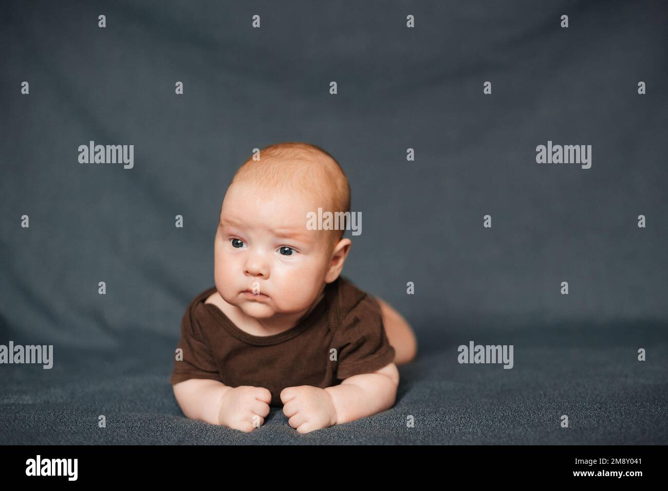 Newborn boy lying on a blanket. Caucasian little baby on tummy with ...