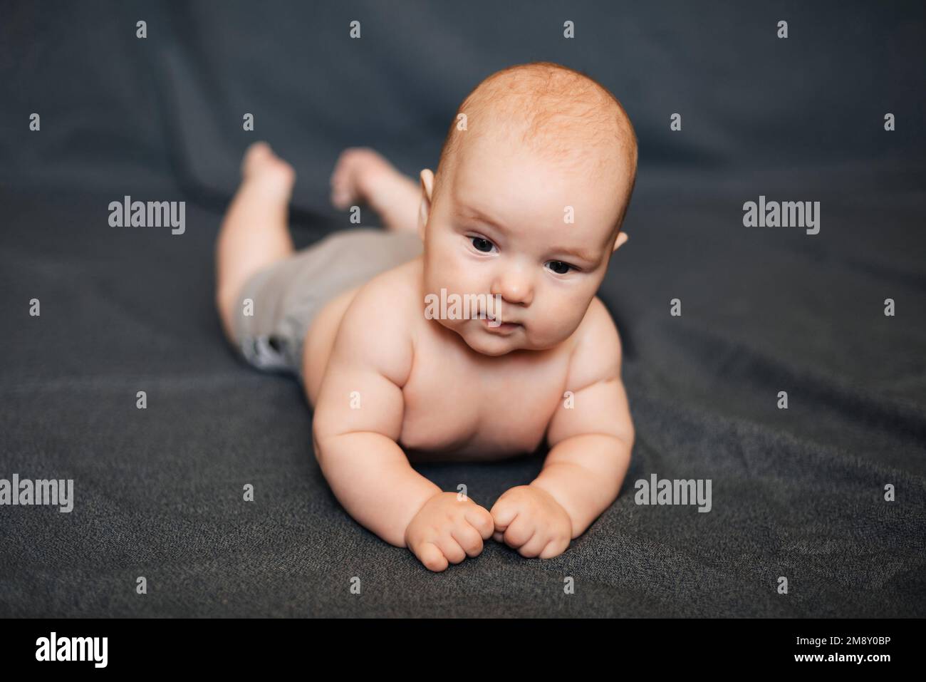 Newborn boy lying on a blanket. Caucasian little baby on tummy Stock ...