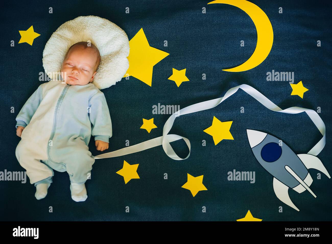 little boy baby sleeping in a suit of the astronaut on the background ...