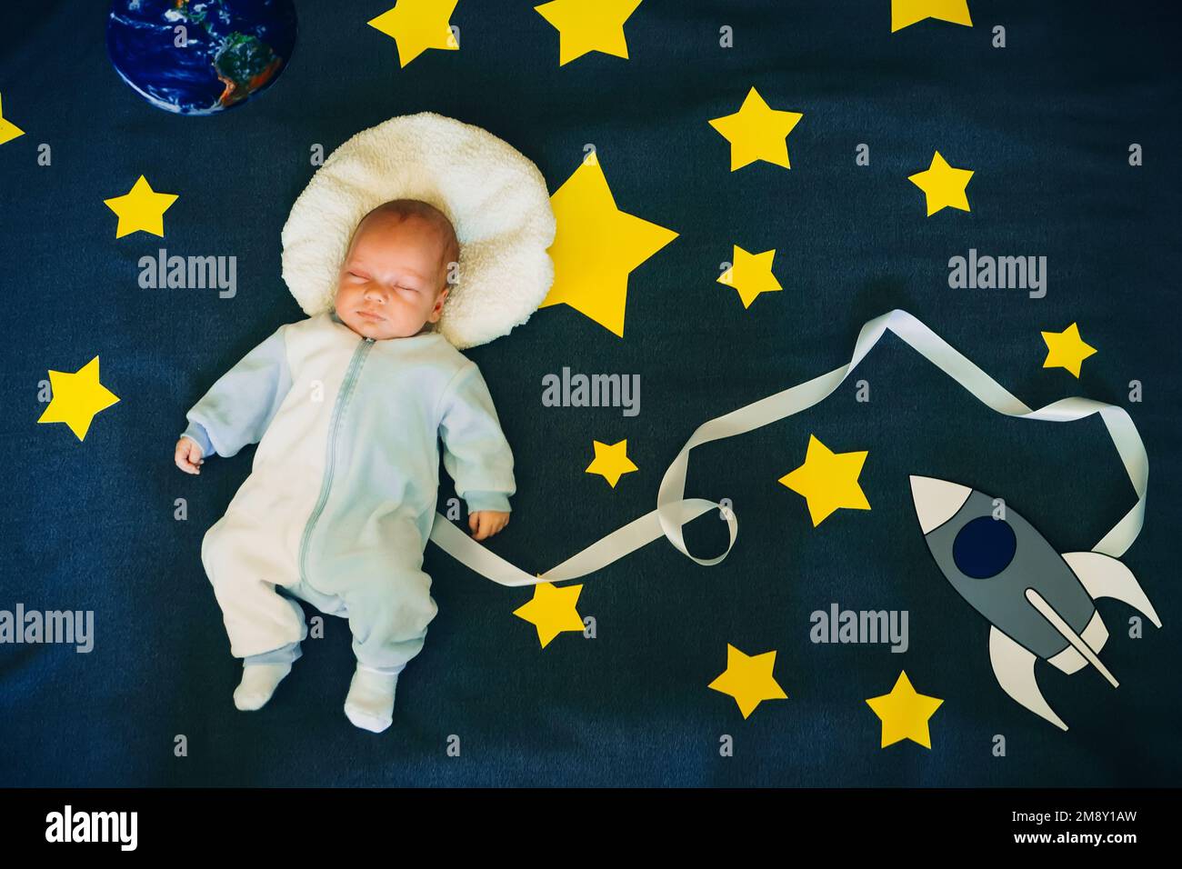 little boy baby sleeping in a suit of the astronaut on the background ...