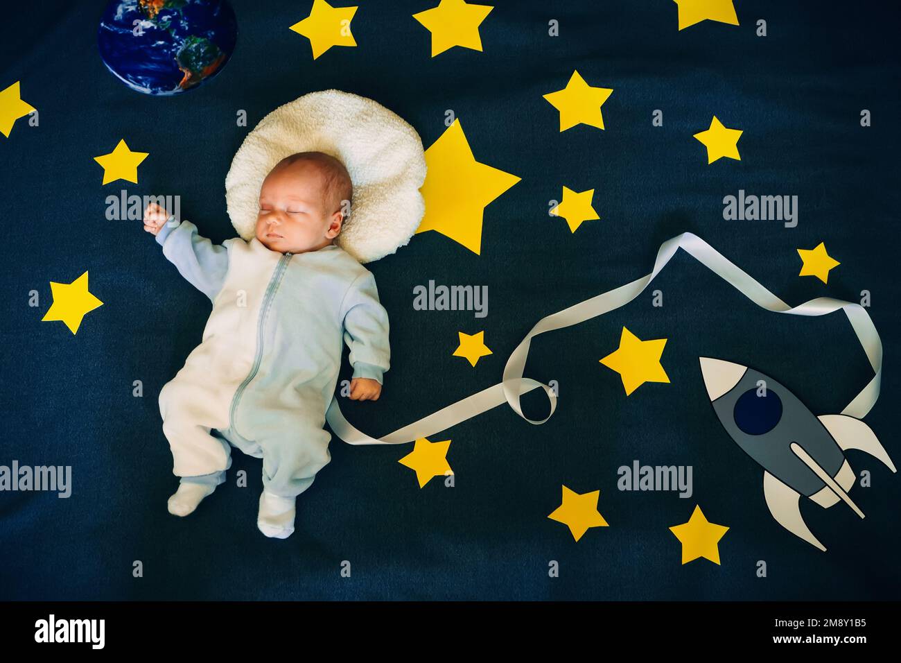 cute little toddler astronaut boy sleeping in the background of the sky ...