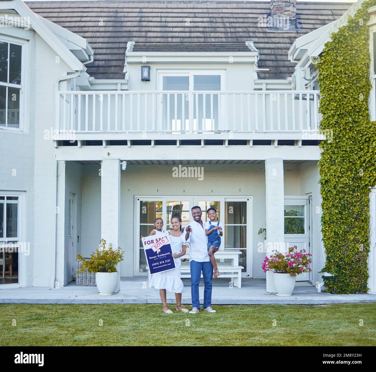 This is our new home. a young family posing in front of a house with a ...