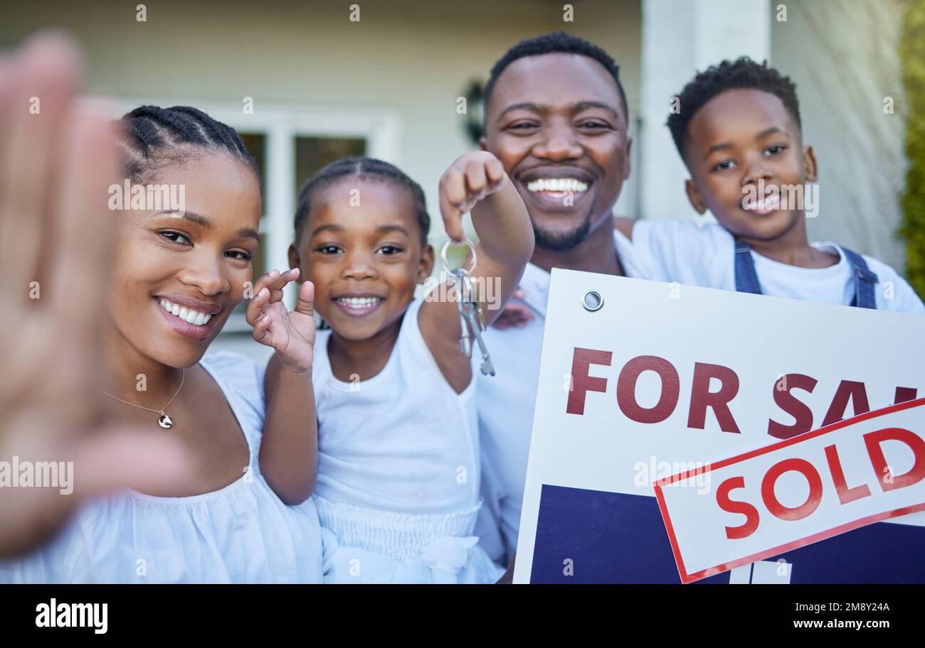 We bought the house. a young family posing in front of a house with a ...