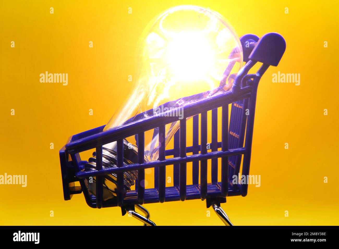 Light bulb inside a shopping cart in a yellow background Stock Photo ...