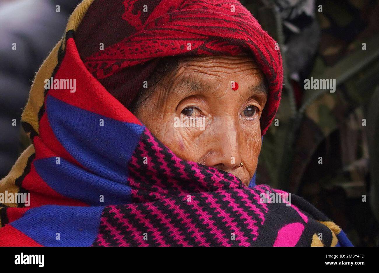 An Elderly Woman Waits Outside A Hospital Where Bodies Of Victims Of A