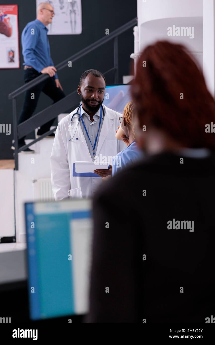 Practitioner doctor talking with nurse discussing patient symptoms ...