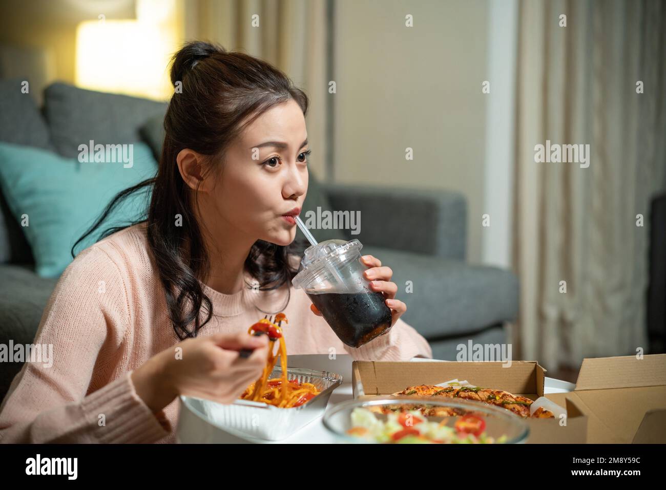 The young lady at home eating take-away Stock Photo - Alamy