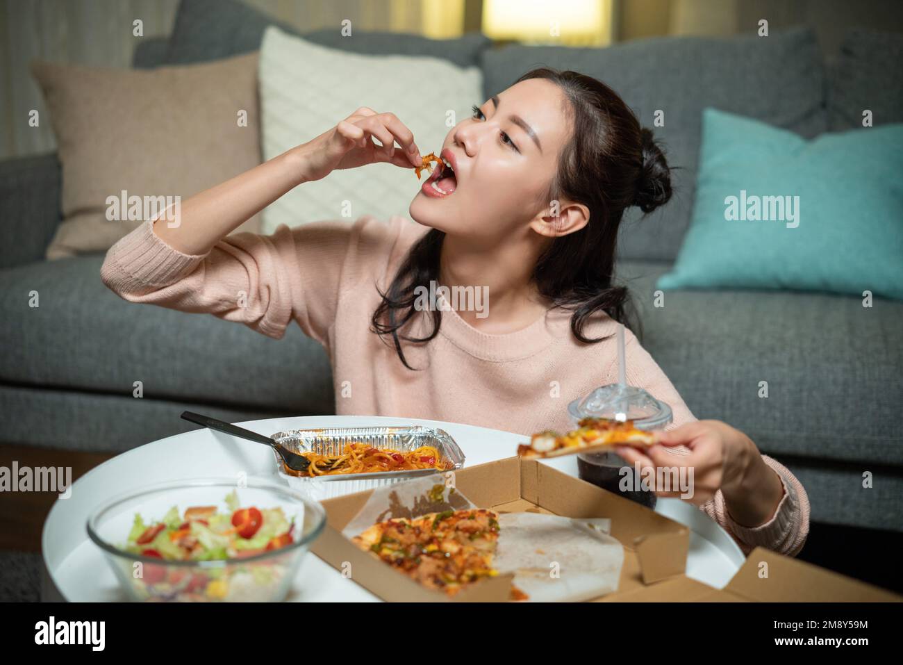 The young lady at home eating take-away Stock Photo - Alamy