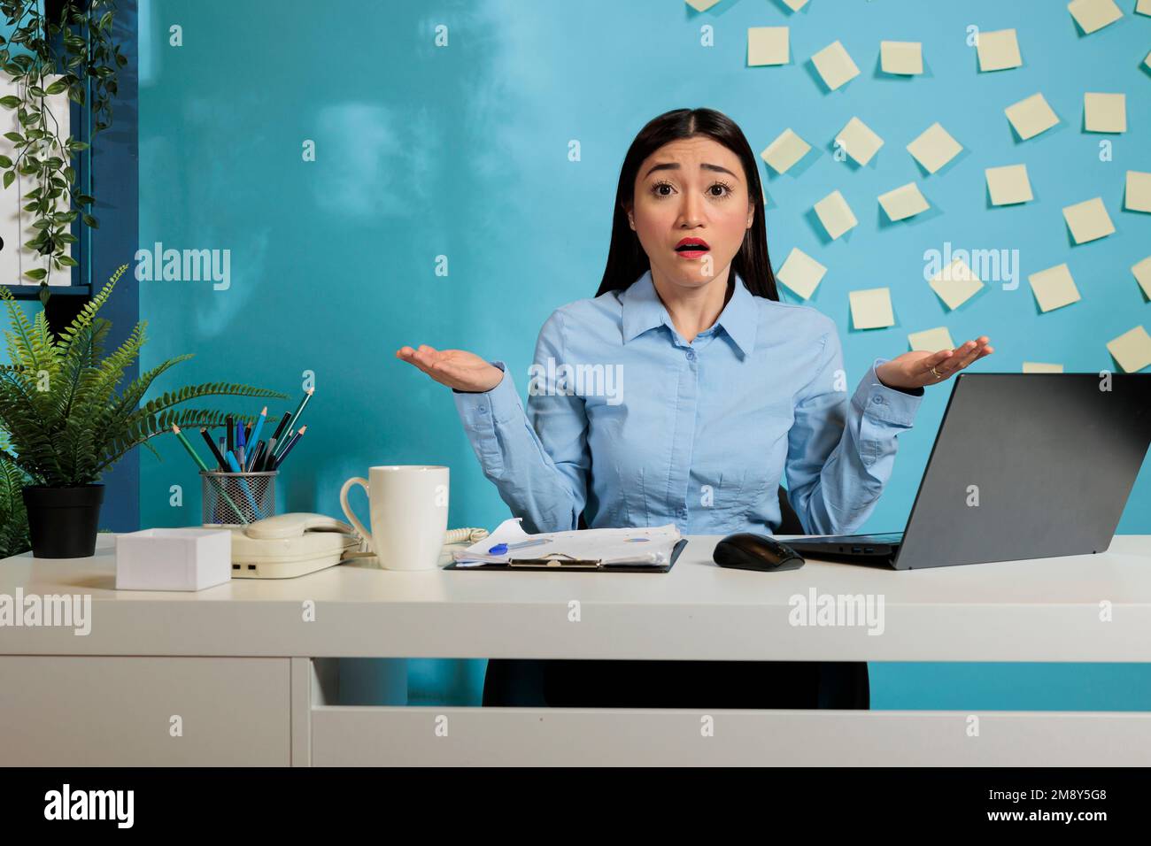 Confused asian woman raising hands and shoulders, unsure of the answer ...