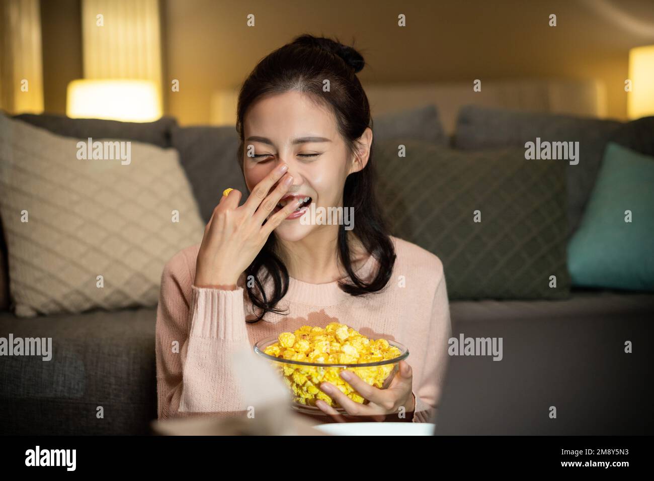The young lady eat at home use the computer Stock Photo - Alamy