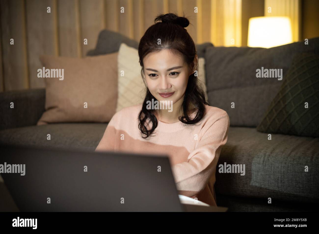 The young lady eat at home use the computer Stock Photo - Alamy
