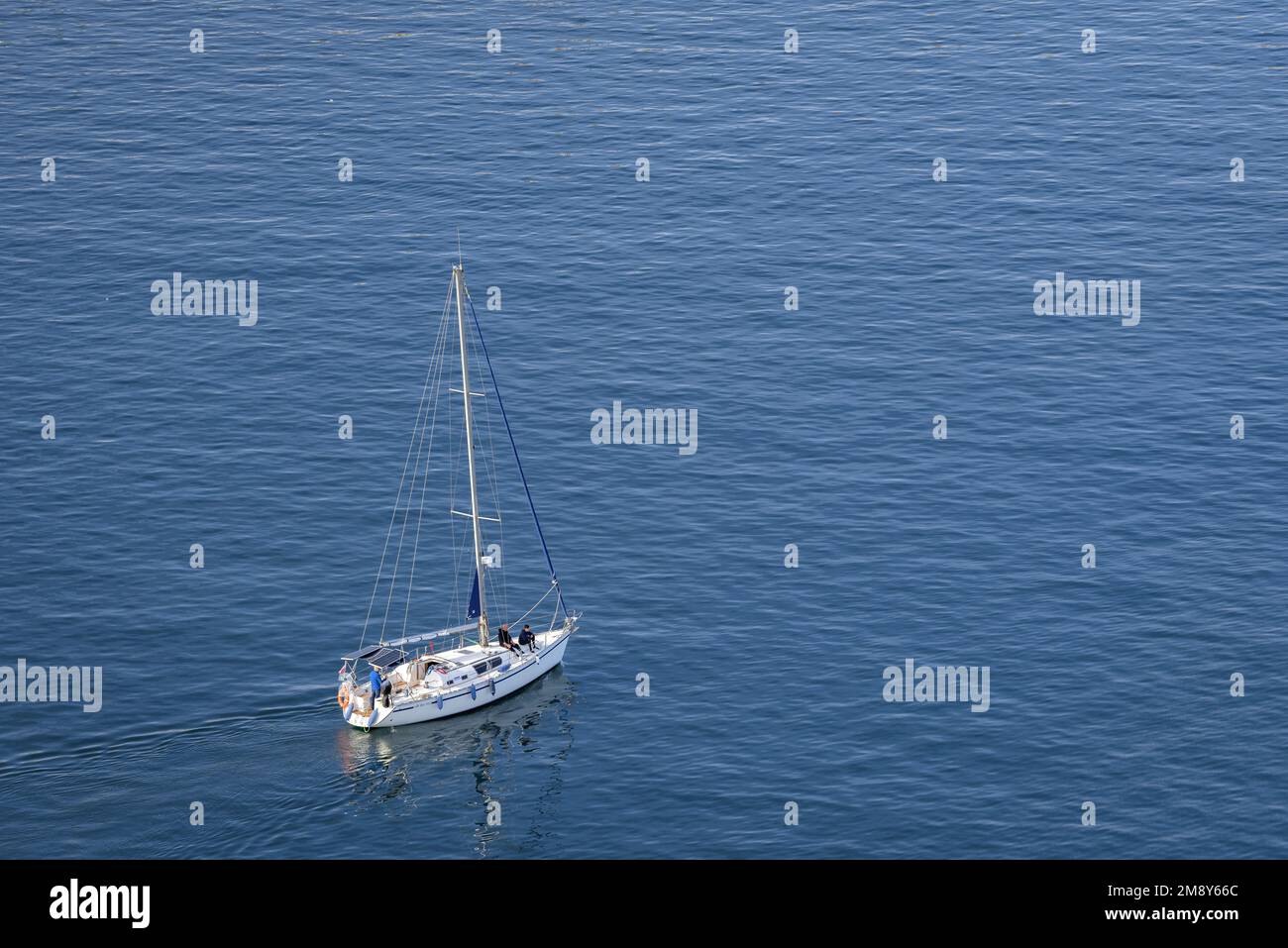 A boat in front of the Barcelona harbor seen from the port cable car on ...