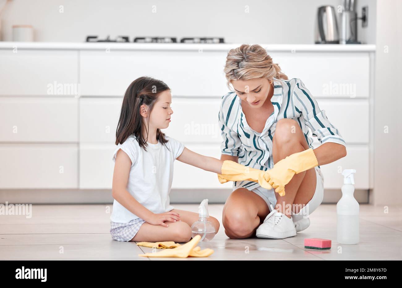Mother and daughter wearing gloves, cleaning the floor at home. Cute ...