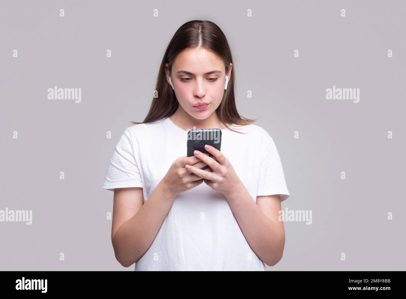 Funny woman uses mobile phone happy texting in social networks. Young ...