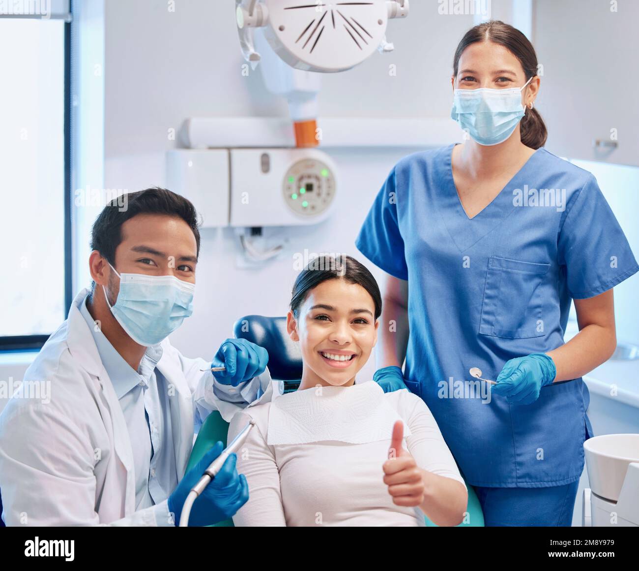 Giving her the permission to smile. a young male dentist giving the ...