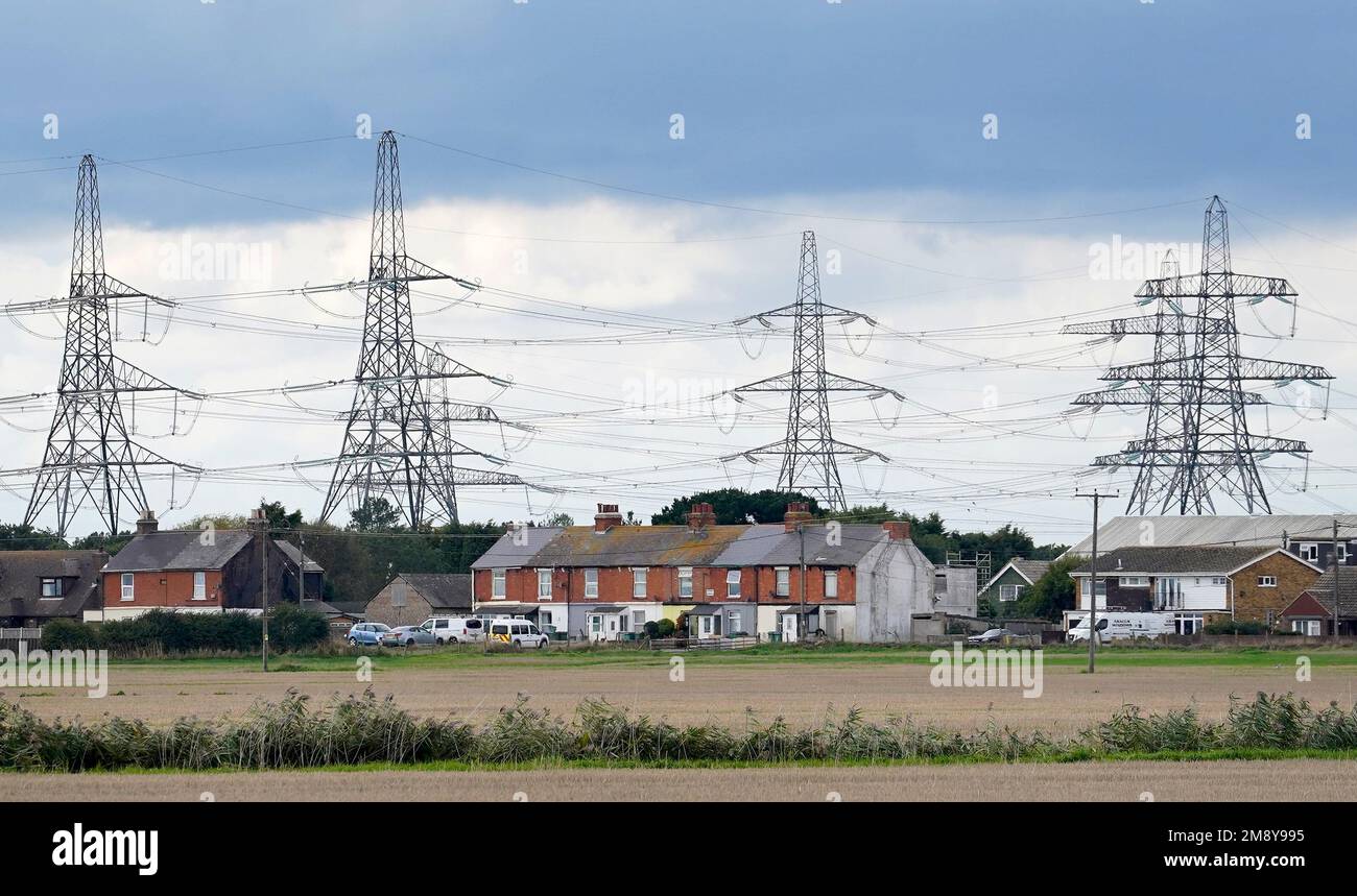 File photo dated 30/09/22 of a view of electricity pylons behind houses ...