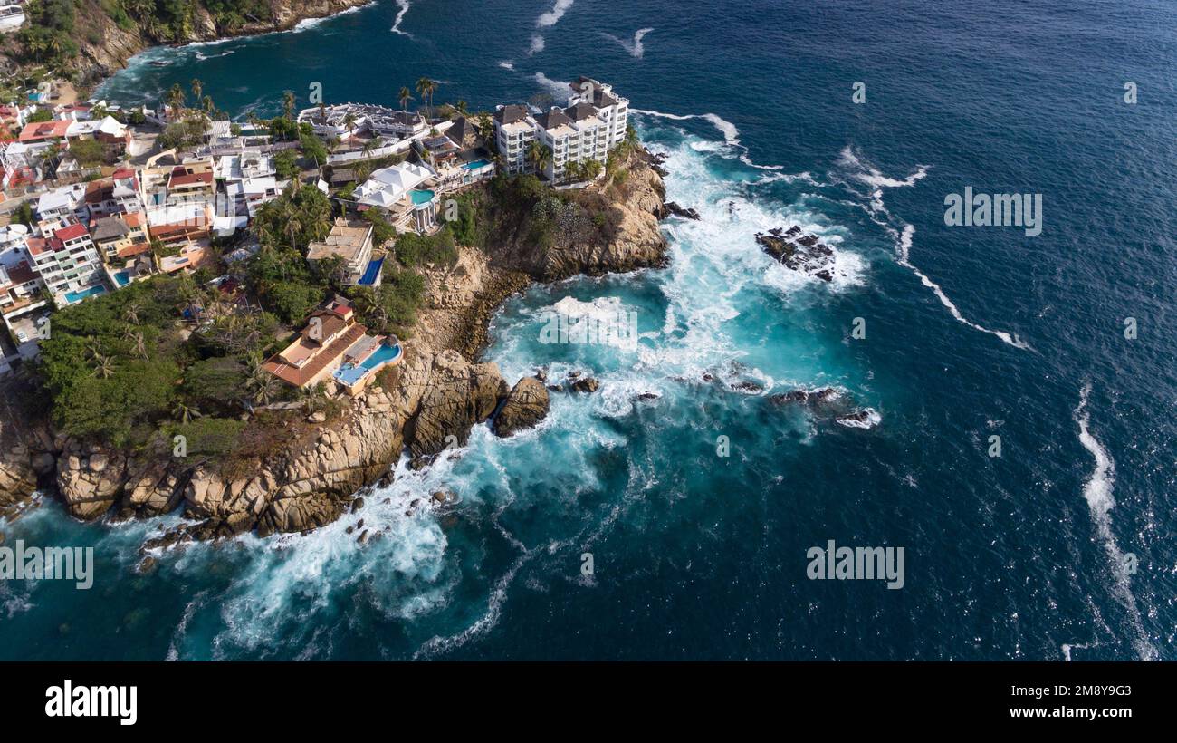 An aerial drone view of Acapulco Bay lines with high residential ...