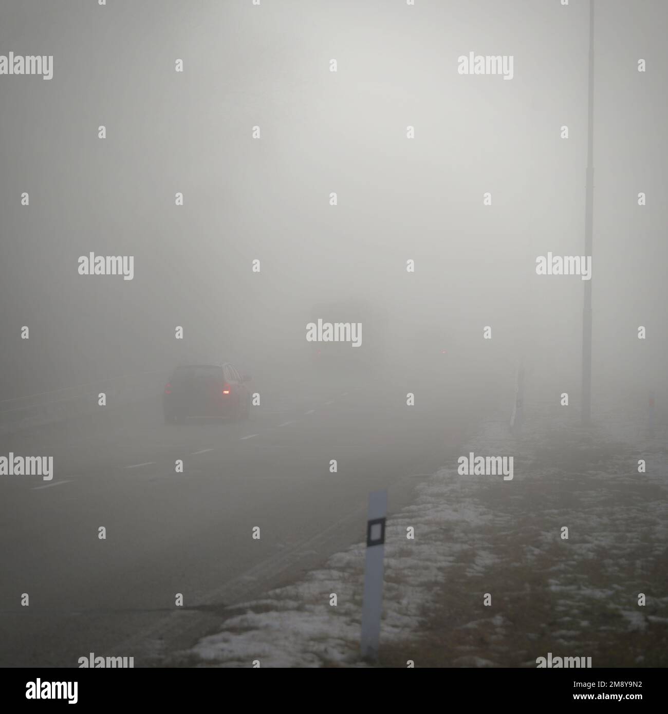 Cars in the fog. Traffic on the road in winter in bad weather. Dangers ...