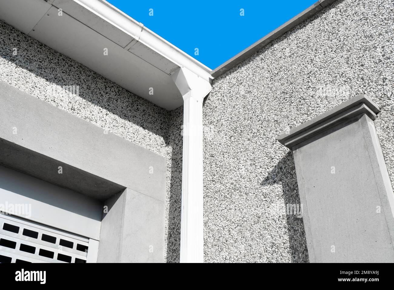 White gutter on the rooftop of house wall rain metal. White plastic ...