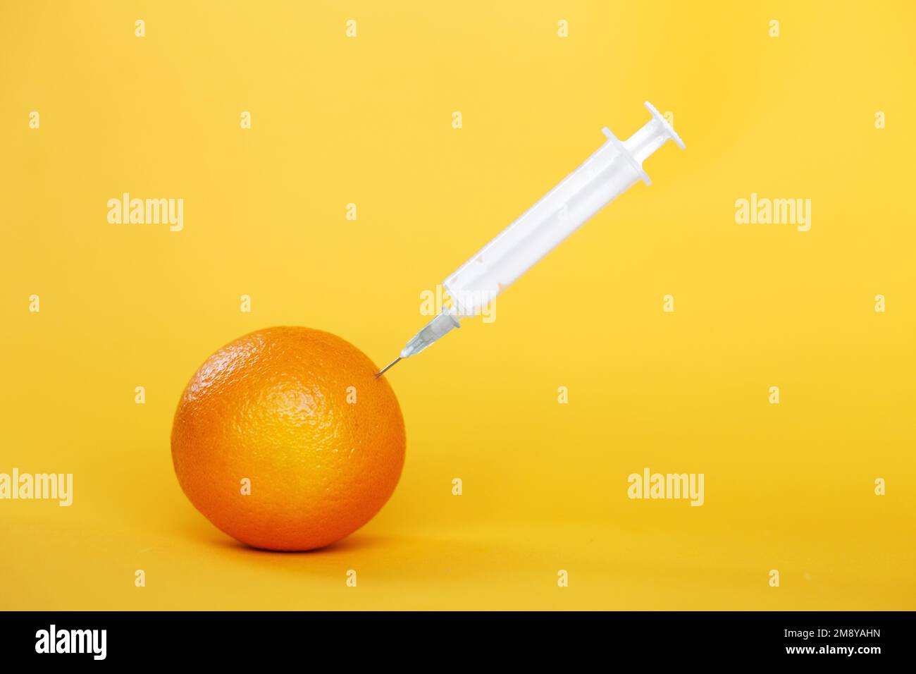 orange fruit with syringe extracting liquid with vitamin C. natural ...